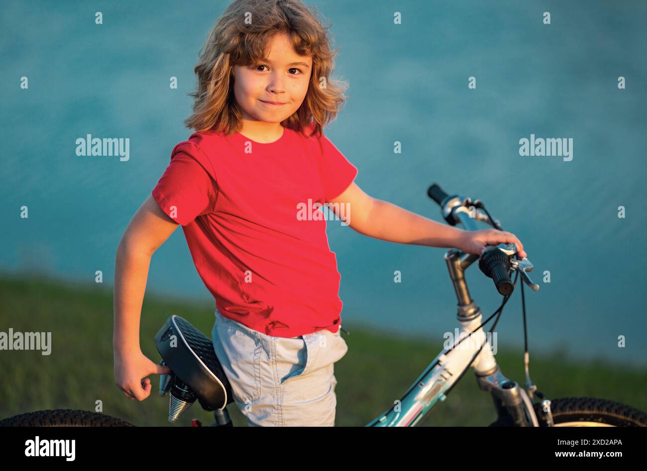 Child riding bicycle. Little kid boy on bicycle along bikeway. Happy ...