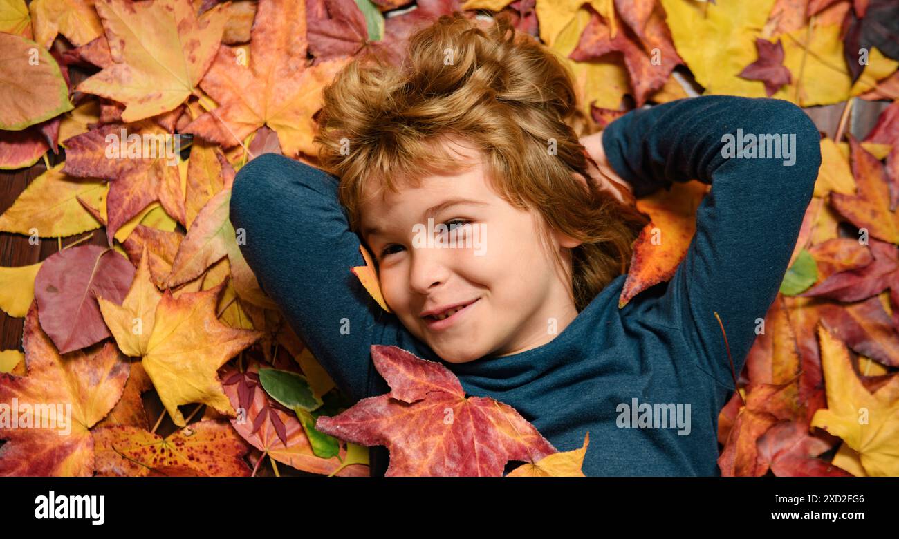 Kids face in autumn outdoor. Child portrait close up, kid lying in ...