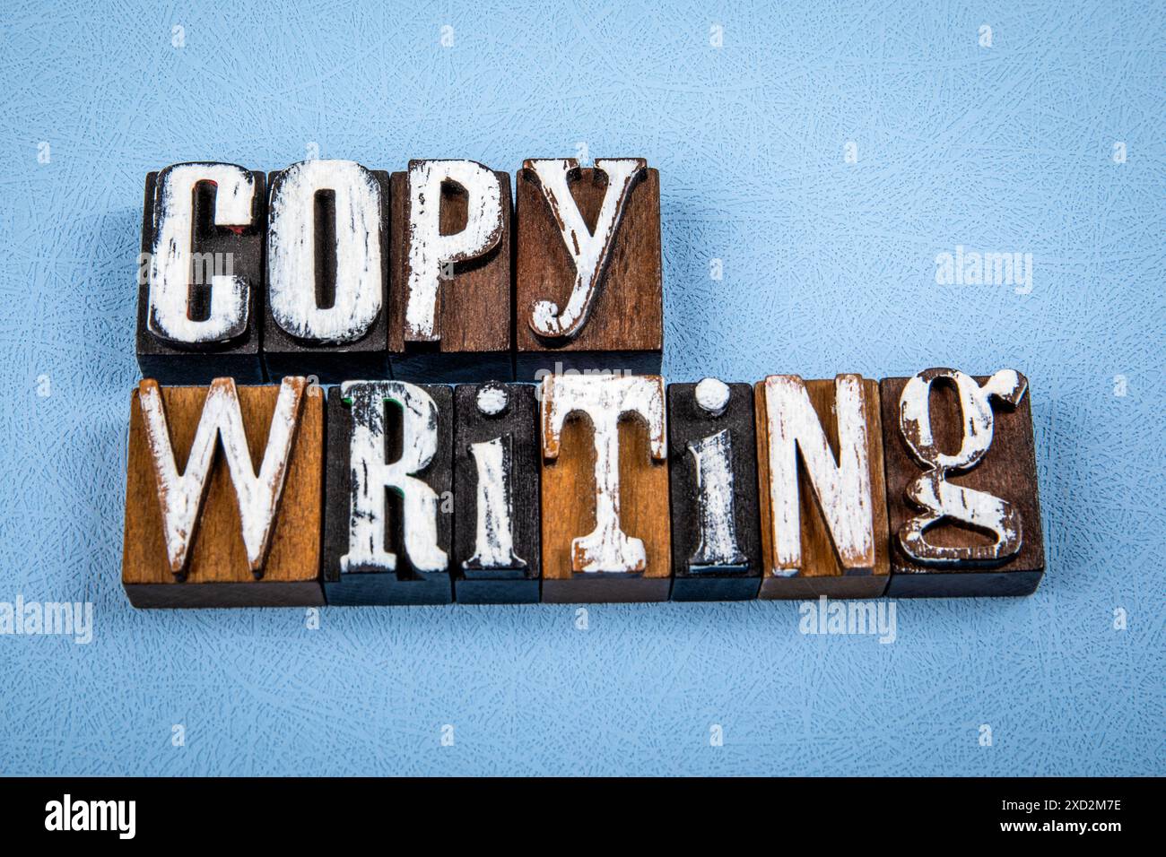 COPYWRITING. Wooden alphabet letter blocks on blue textured background ...