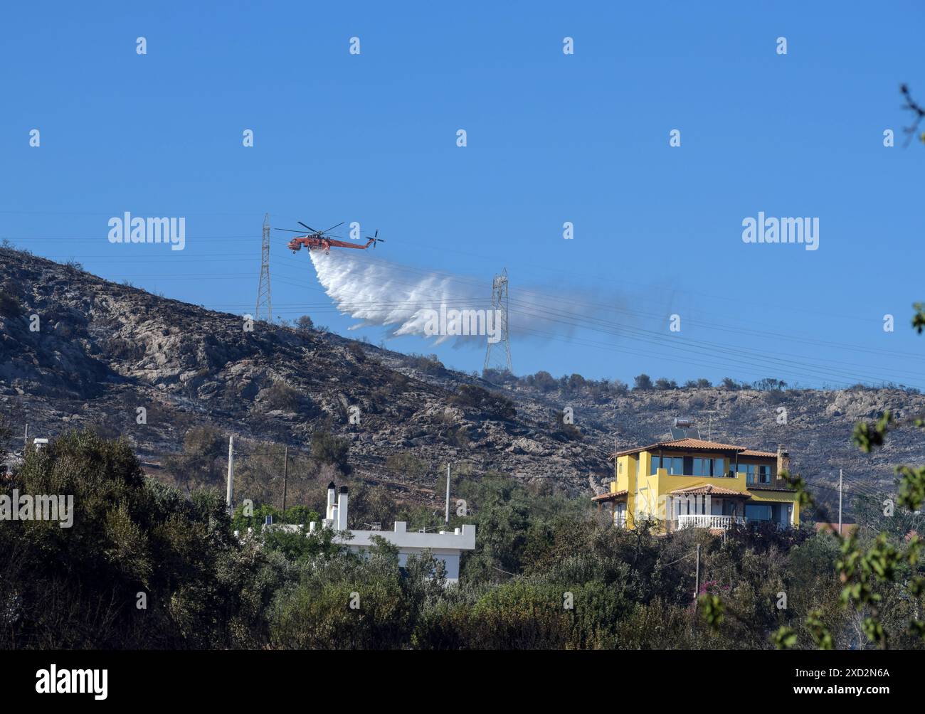 Athens, Greece. 19 June 2024. A firefighting helicopter makes a water ...