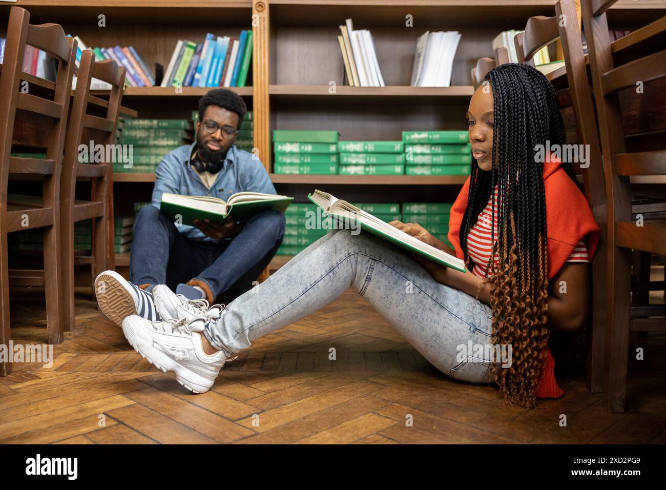 African american students reading books while sitting on the floor in ...