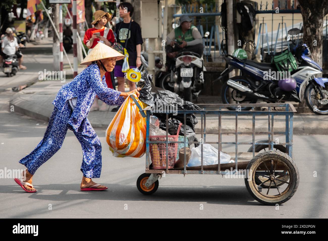 Vietnamese old woman pushing a cart with garbage bags. Hoi an, Vietnam ...