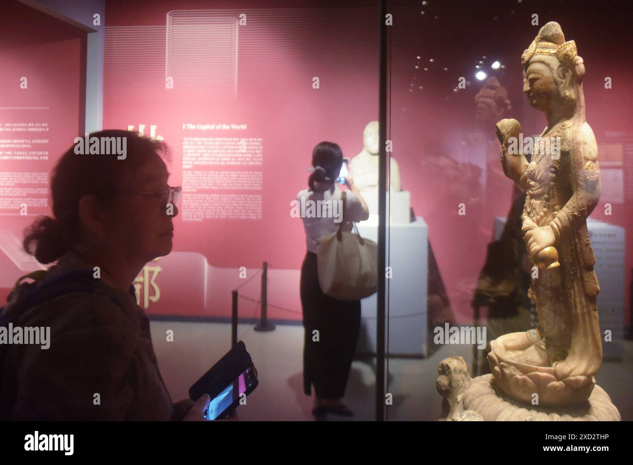 HANGZHOU, CHINA - JUNE 20, 2024 - Visitors look at a statue of a ...