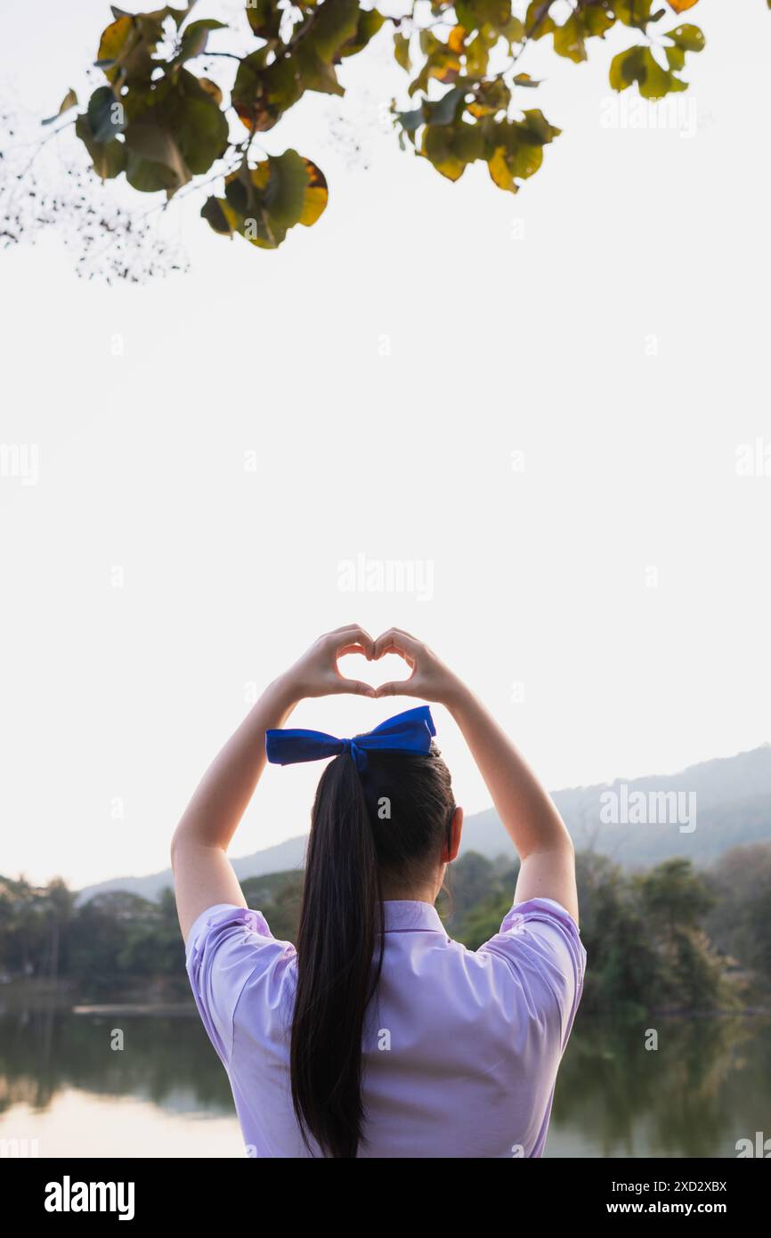 woman raises her hands make heart symbol meaning love and friendship on ...