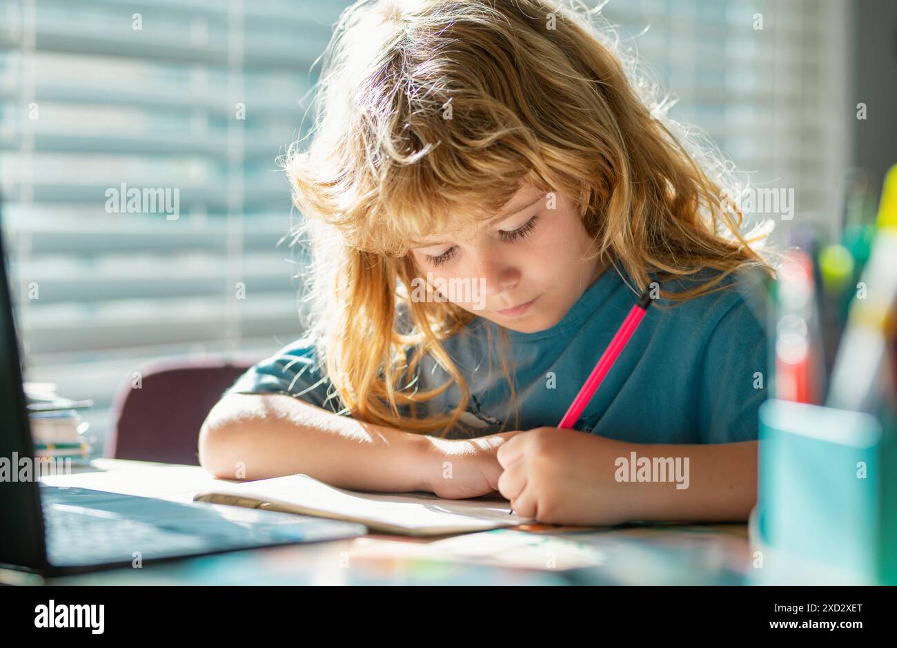 Child writing at school. Funny child girl doing homework writing and ...