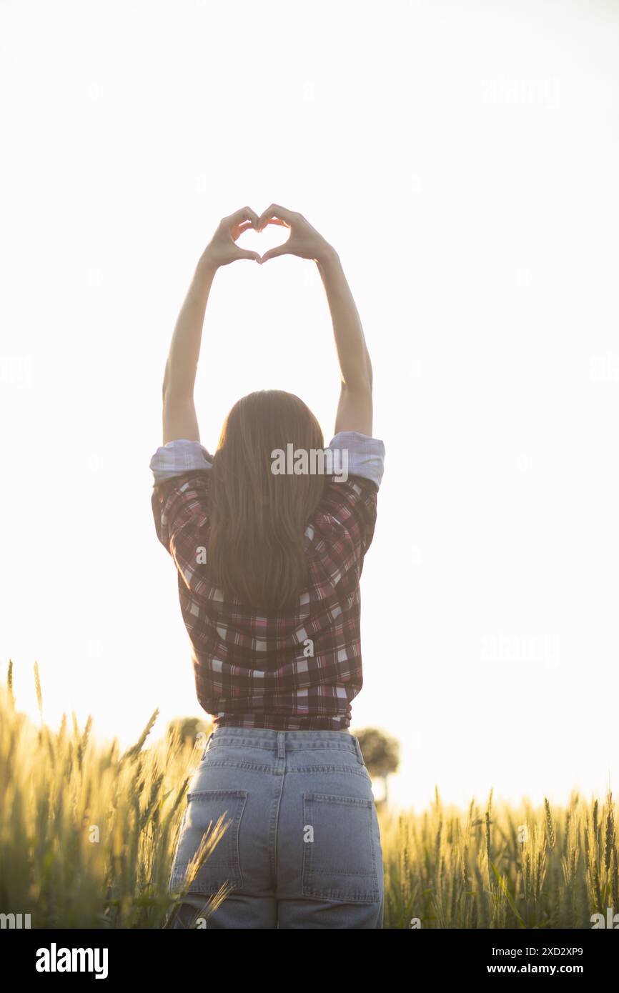 woman raises her hands make heart symbol meaning love and friendship on ...