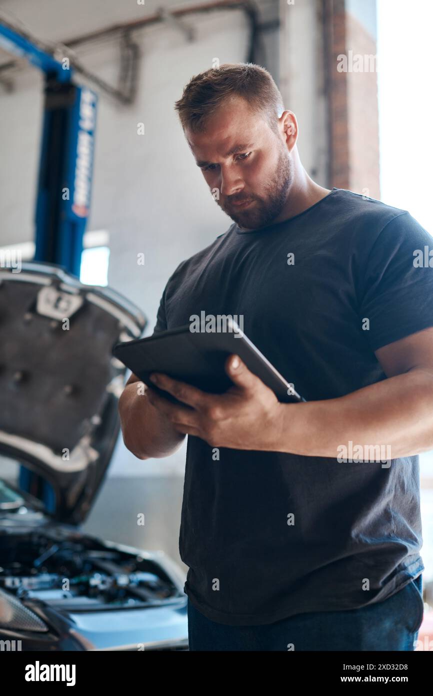 Man, car mechanic and garage with tablet for inspection or maintenance ...