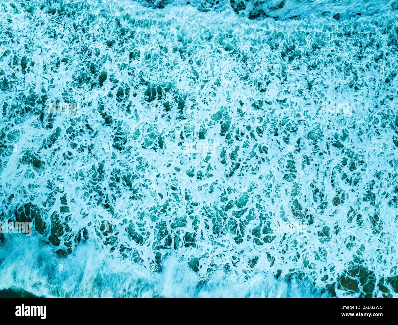 Overhead view turquoise stormy ocean waves with white foam in the ocean ...
