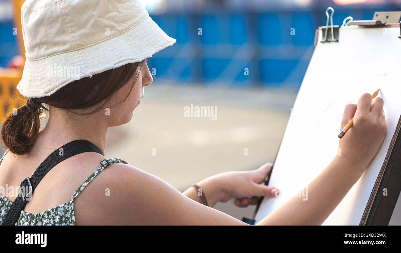 Cute teenage girl drawing at easel outdoors, in the courtyard of the ...