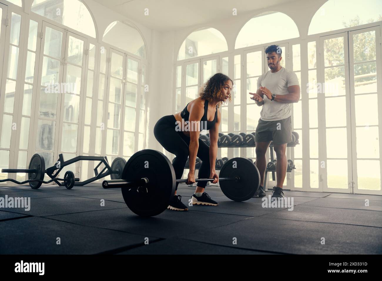 Two fit multiracial young adults in sports clothing doing weight ...