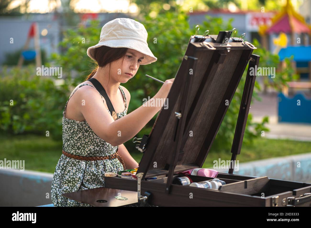 Cute teenage girl drawing at easel outdoors, in the courtyard of the ...