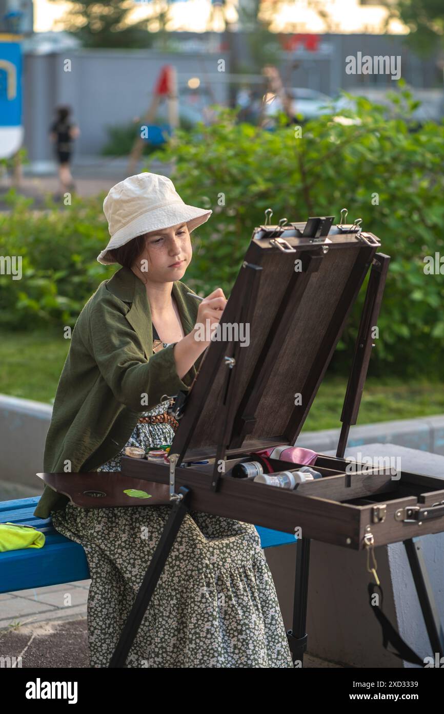 Cute teenage girl drawing at easel outdoors, in the courtyard of the ...