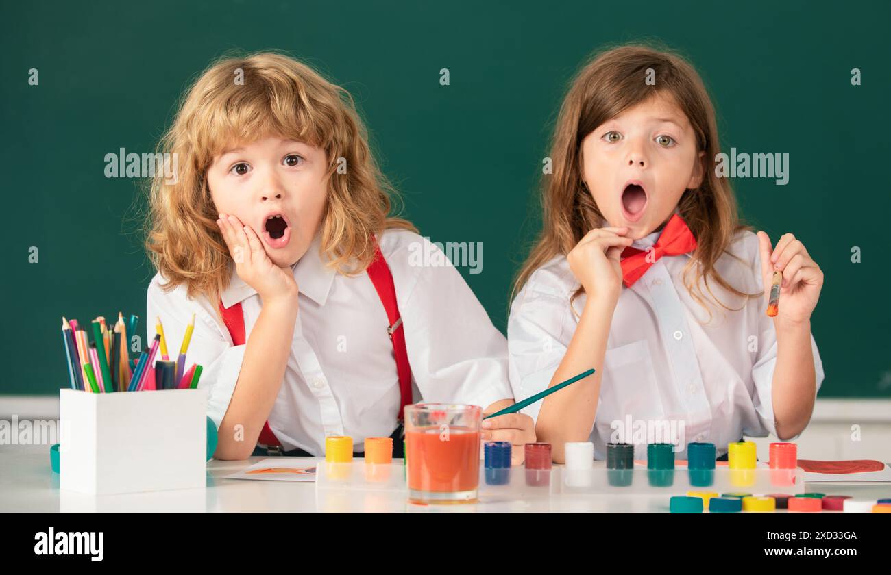 Excited school surprised children drawing a colorful pictures with ...