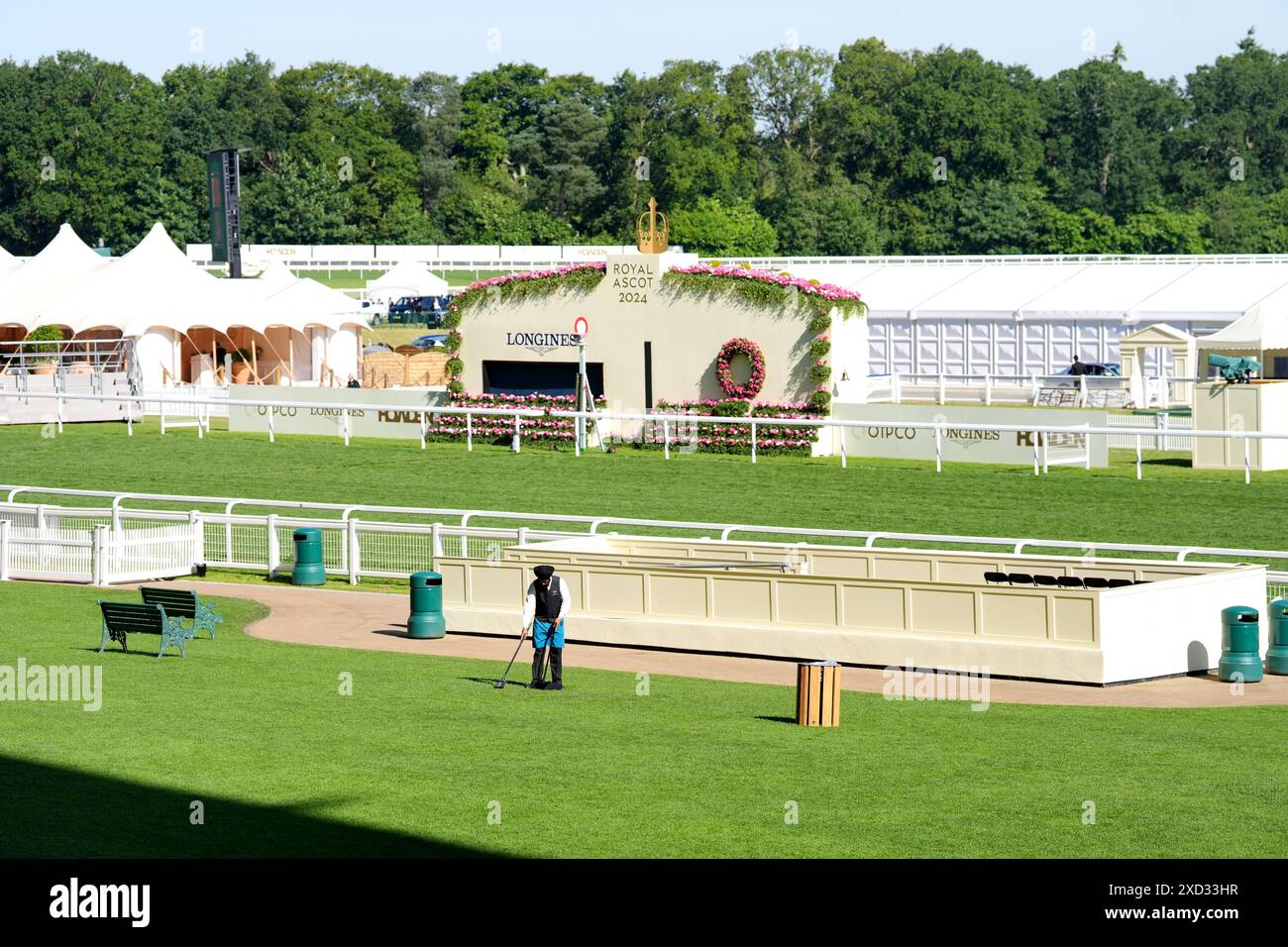A member of the ground staff sweeps the grass in front of the ...
