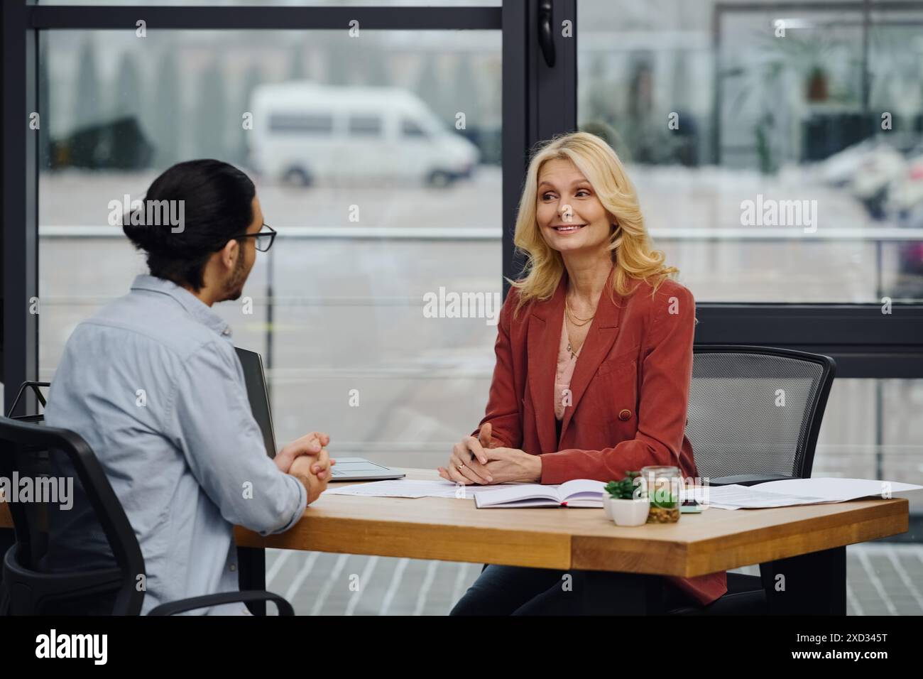 Job seeker interviewing at a modern office desk by woman Stock Photo ...