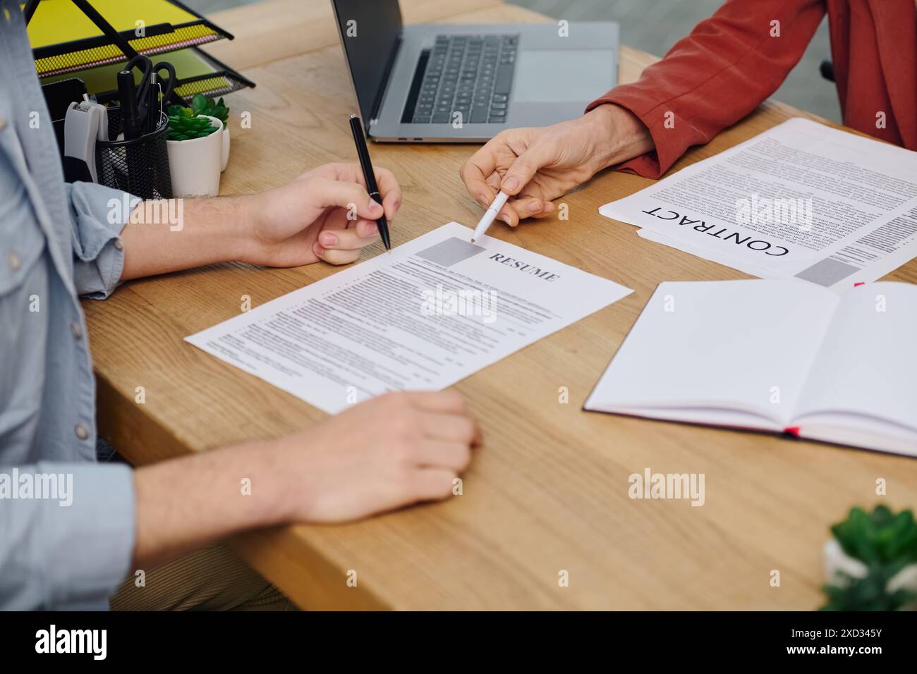 Two people at a table, signing a document during a job interview Stock ...