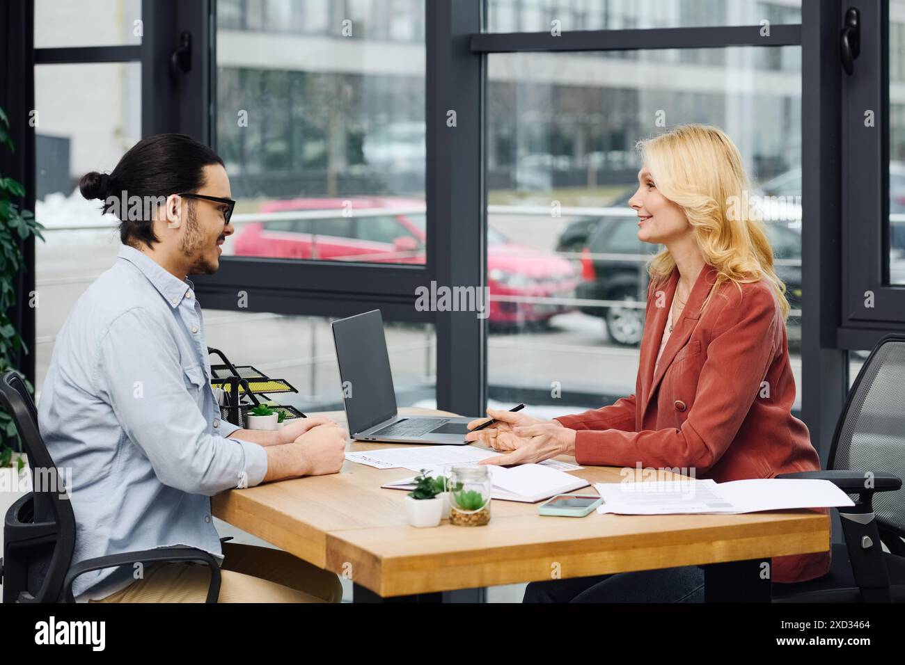 Man and woman engaging in discussion at a desk in an office setting ...