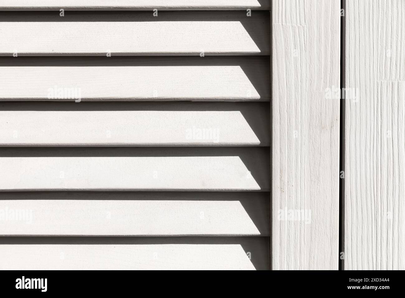 White wooden door with louvres. Light and shadows. Abstract texture ...