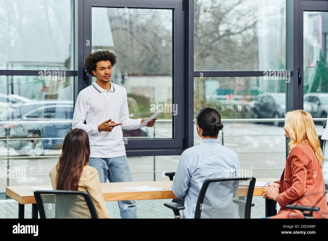A man presenting to a group of people in an office setting Stock Photo ...