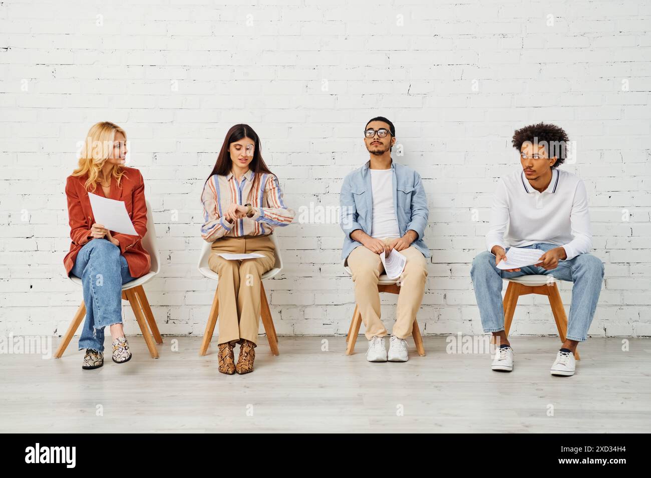 A diverse group of people seated in a row against a brick wall Stock ...