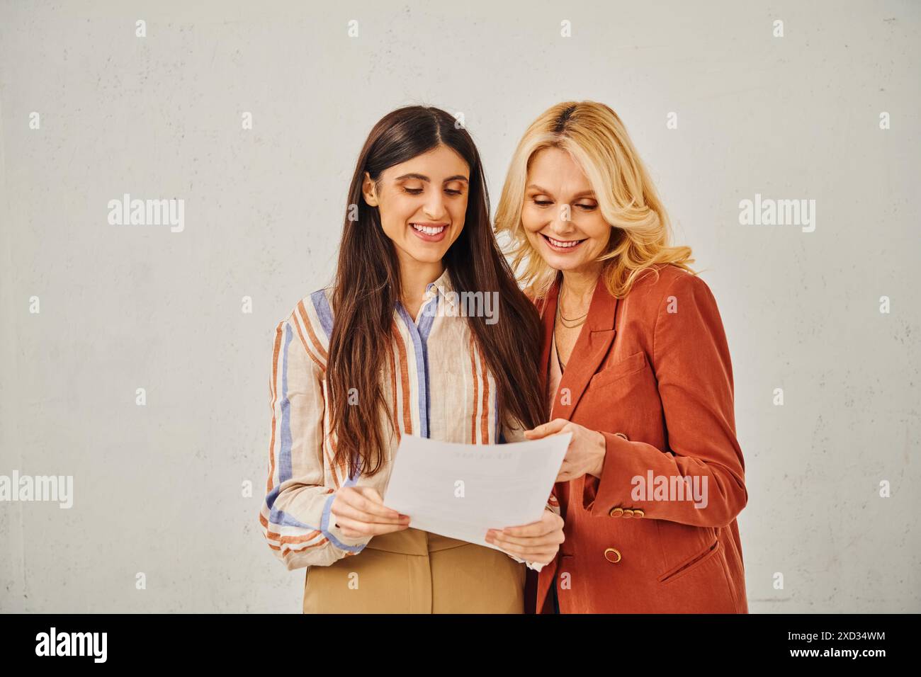 Two women intensely studying a paper together while at job interview ...