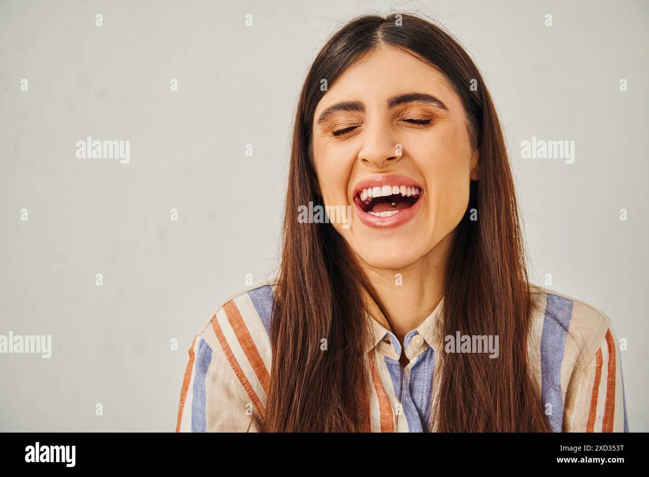 A young woman with her mouth open, laughing joyfully Stock Photo - Alamy