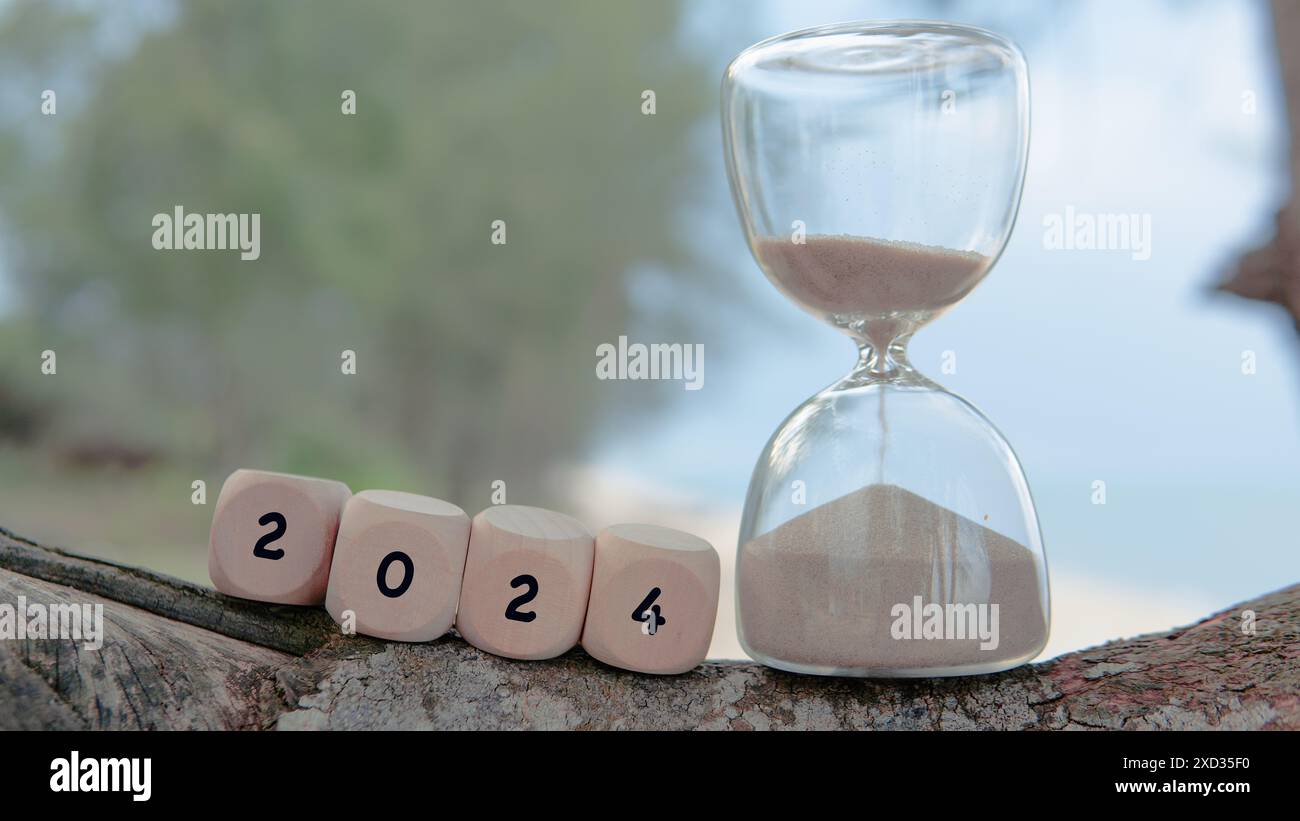 An hour glass with the sand dropping down like time flying away to mark ...