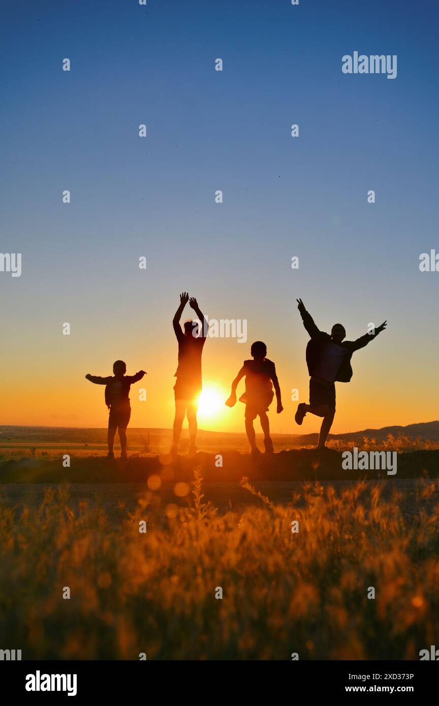 Silhouette of jumping kids against summer sunset Stock Photo - Alamy