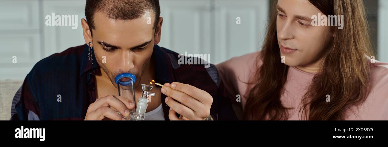 A gay couple in casual attire, together at home, man lighting marijuana ...