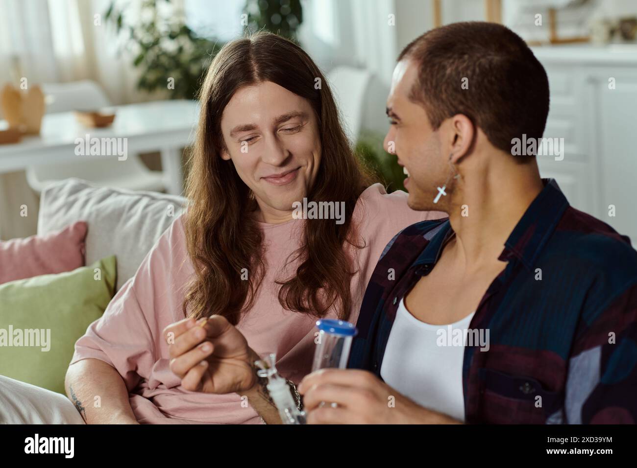 a gay couple, sit comfortably on a couch, enjoying each others company ...