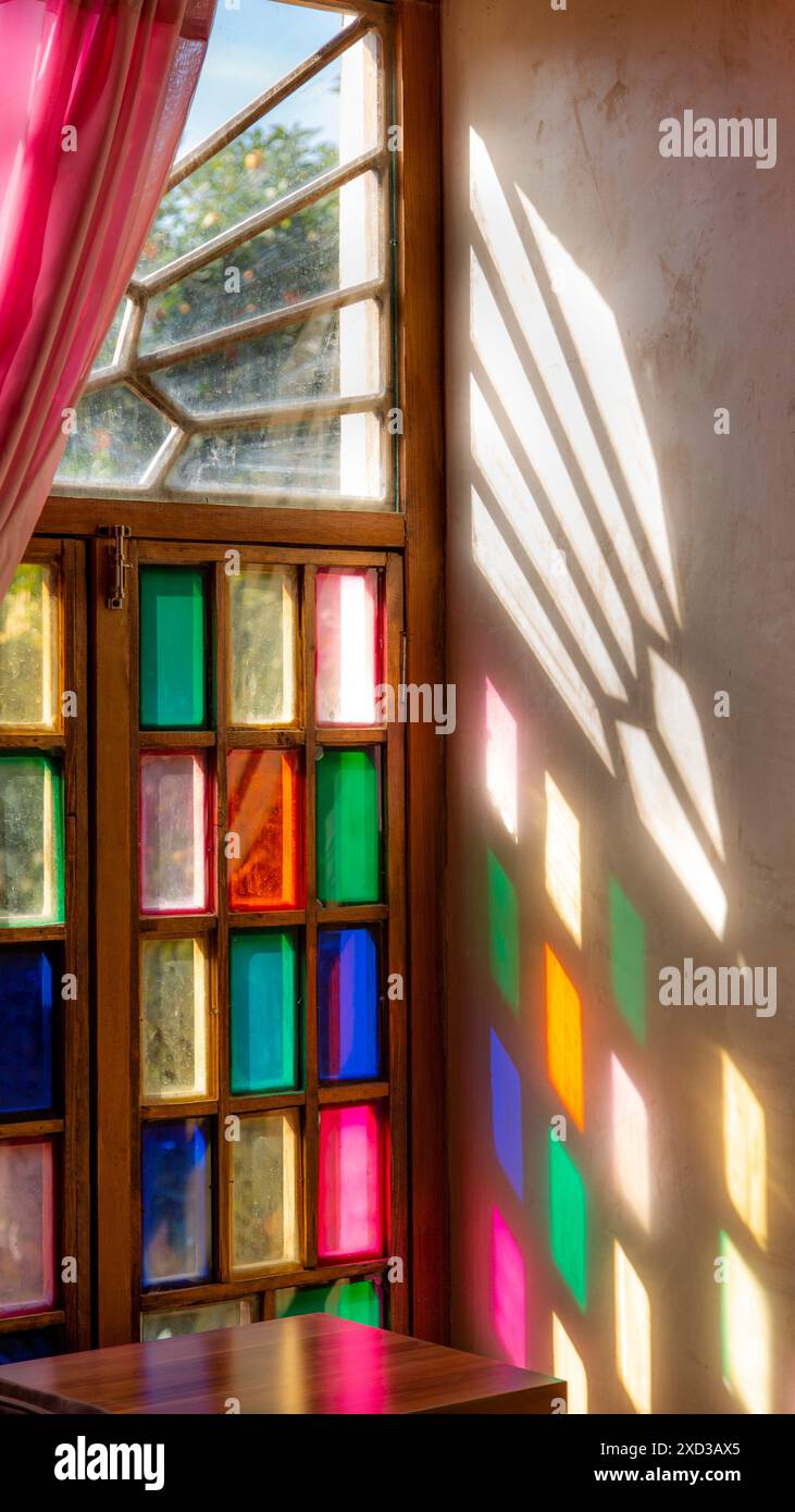 Afternoon sunlight through an old stained glass wooden window in a ...