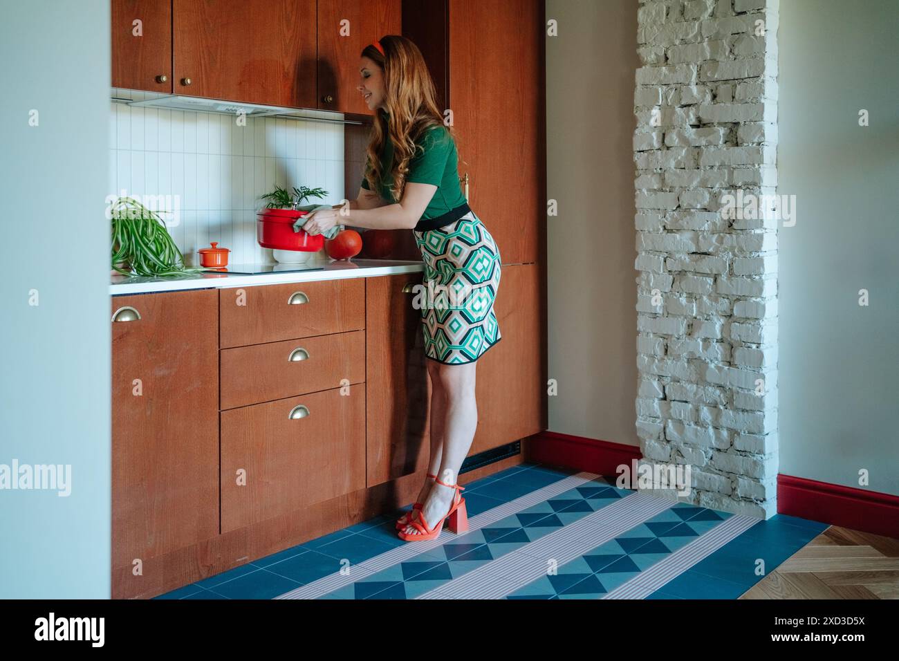 A smiling woman in a 1950s-style kitchen, wearing a patterned dress and ...