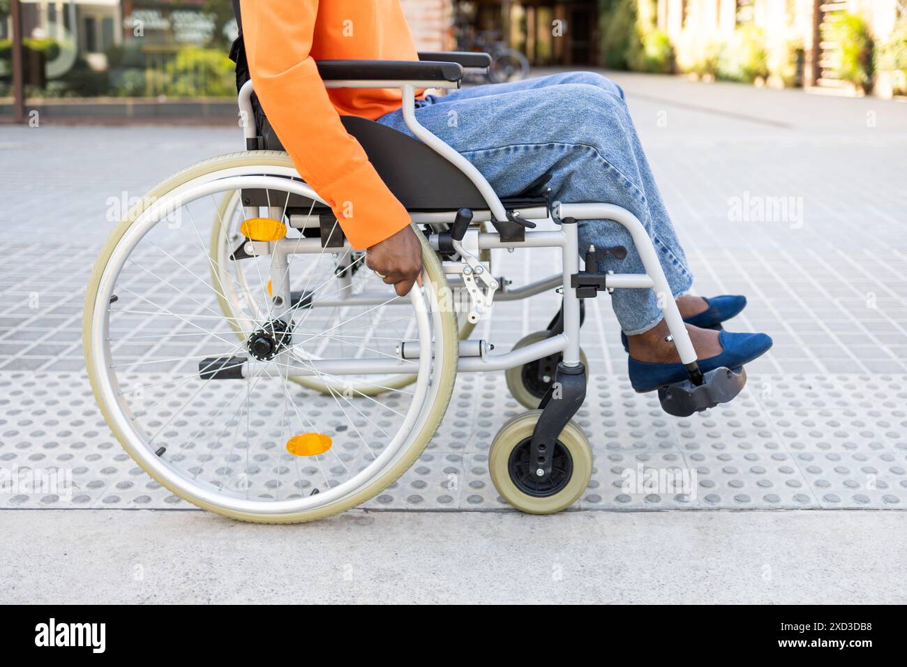 A young black woman navigates a wheelchair outside, showcasing mobility ...
