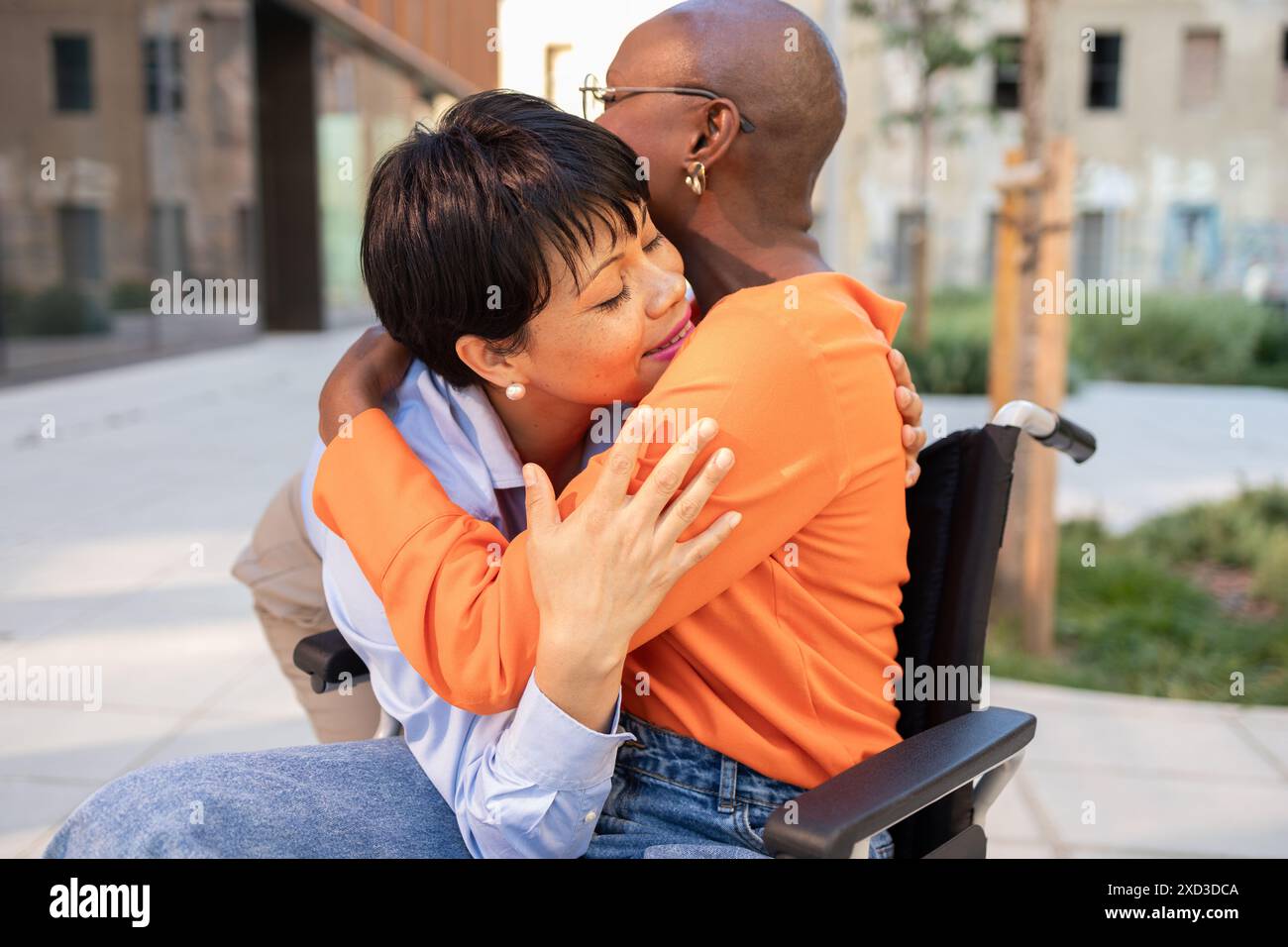An affectionate hug between two women, where one is seated in a ...