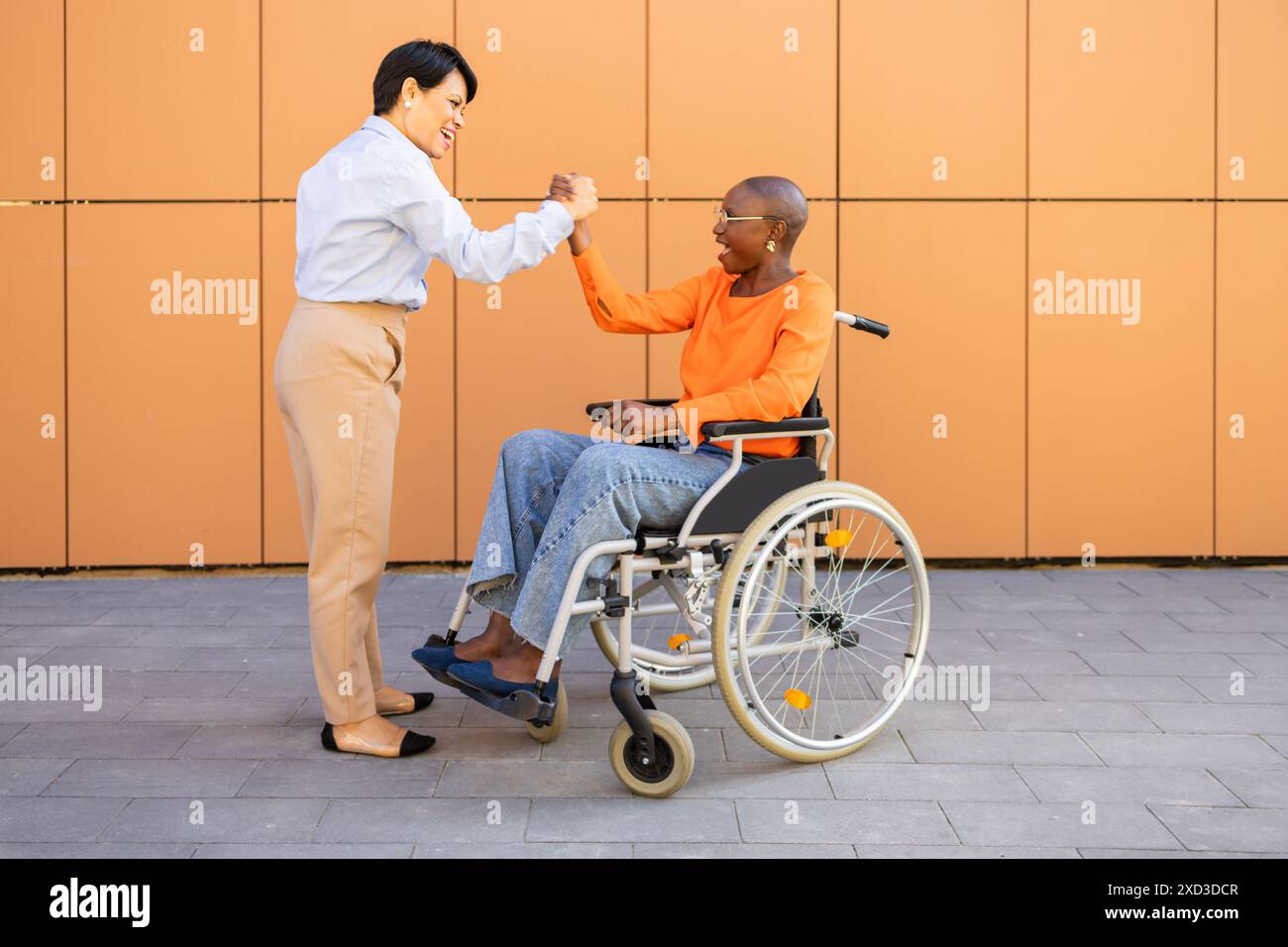 African American woman in a wheelchair engaging warmly with a Latin ...