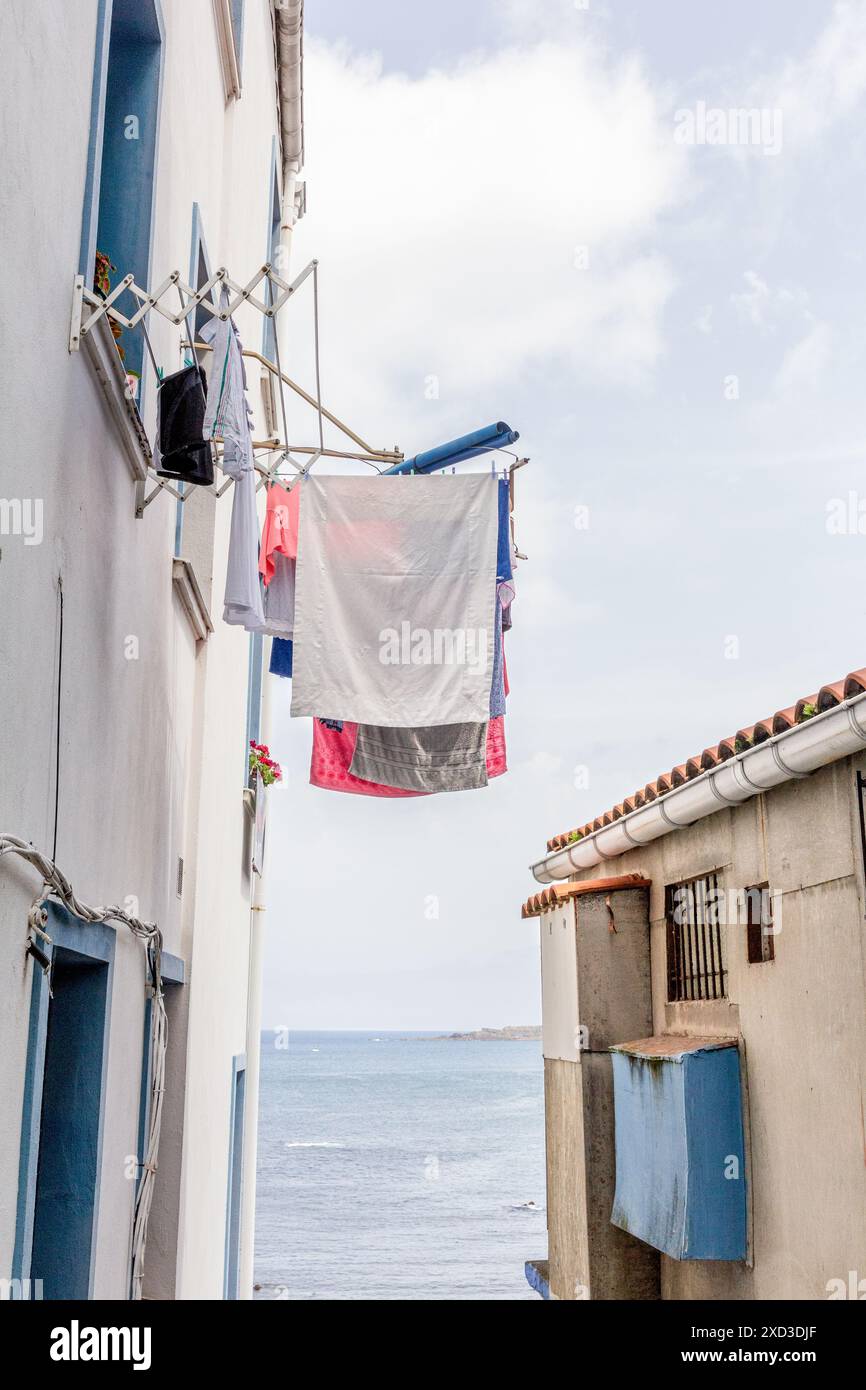 A charming coastal alleyway featuring laundry drying on a clothesline ...