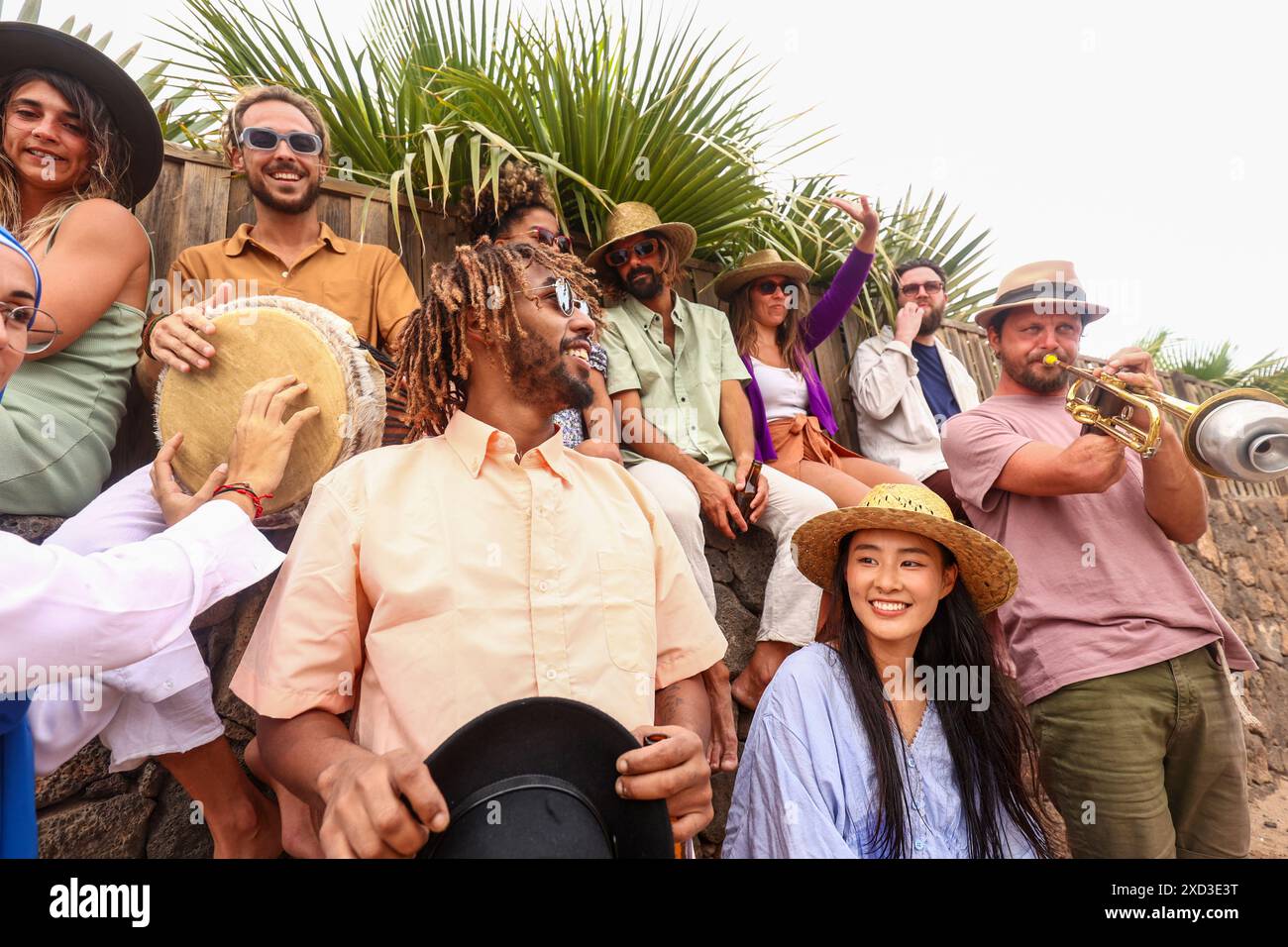 From below a multiracial group of friends gathers for a party outdoors ...
