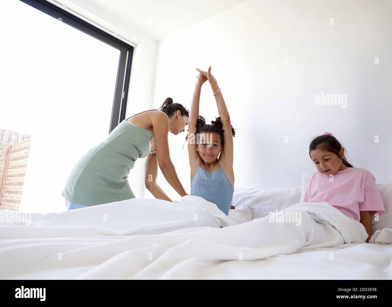 A multiethnic family engages in their morning routine. A mother helps ...