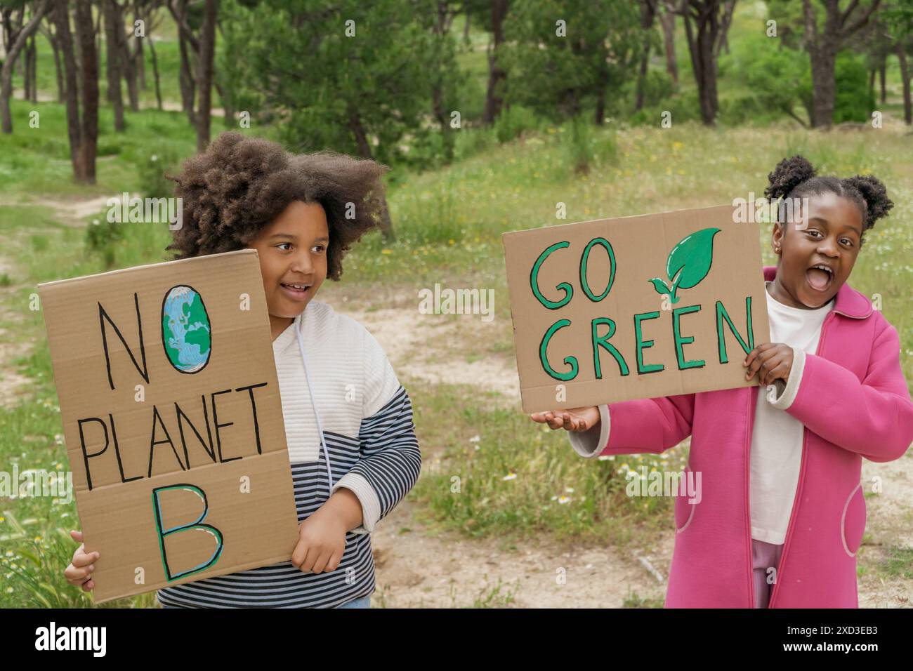 Two enthusiastic black girls in a lush green park, proudly displaying ...