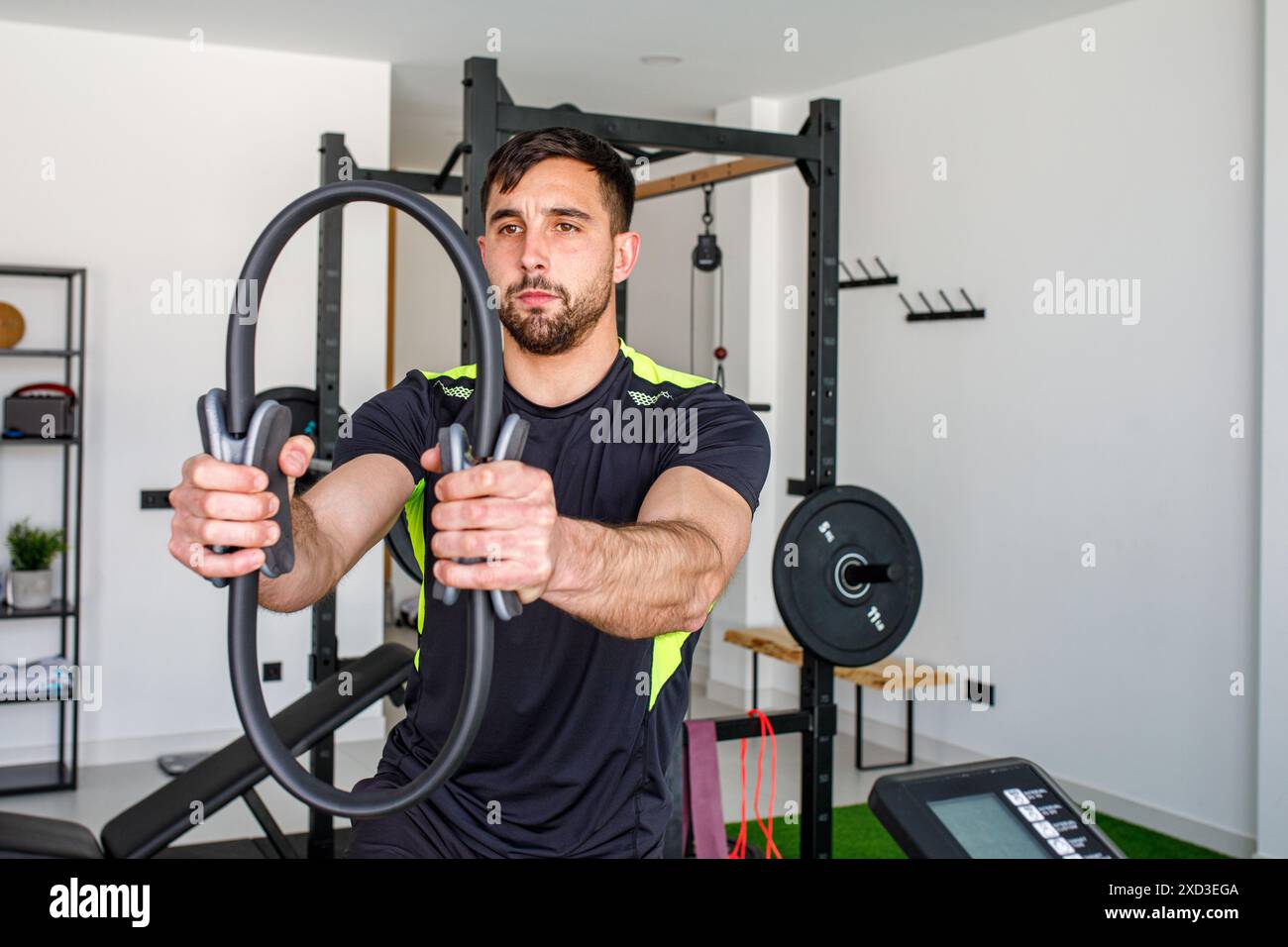 An athletic man concentrates on exercise with gym rings in a well ...