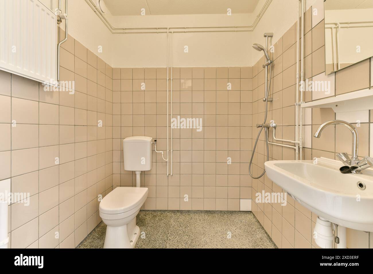 Basic bathroom featuring beige tiled walls, a toilet, a sink, and a ...