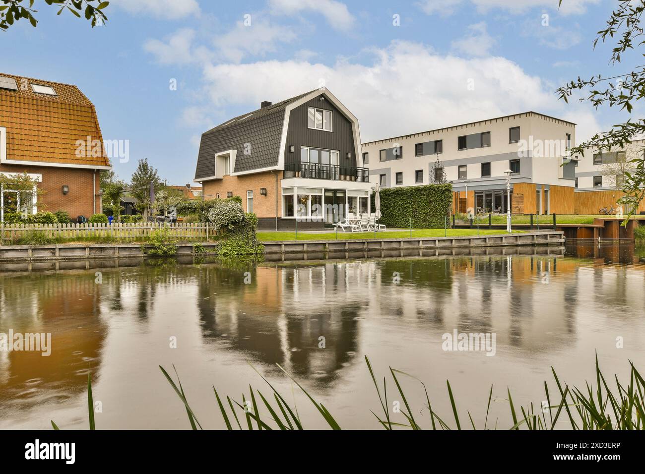 An elegant waterfront home featuring a lush garden and modern ...