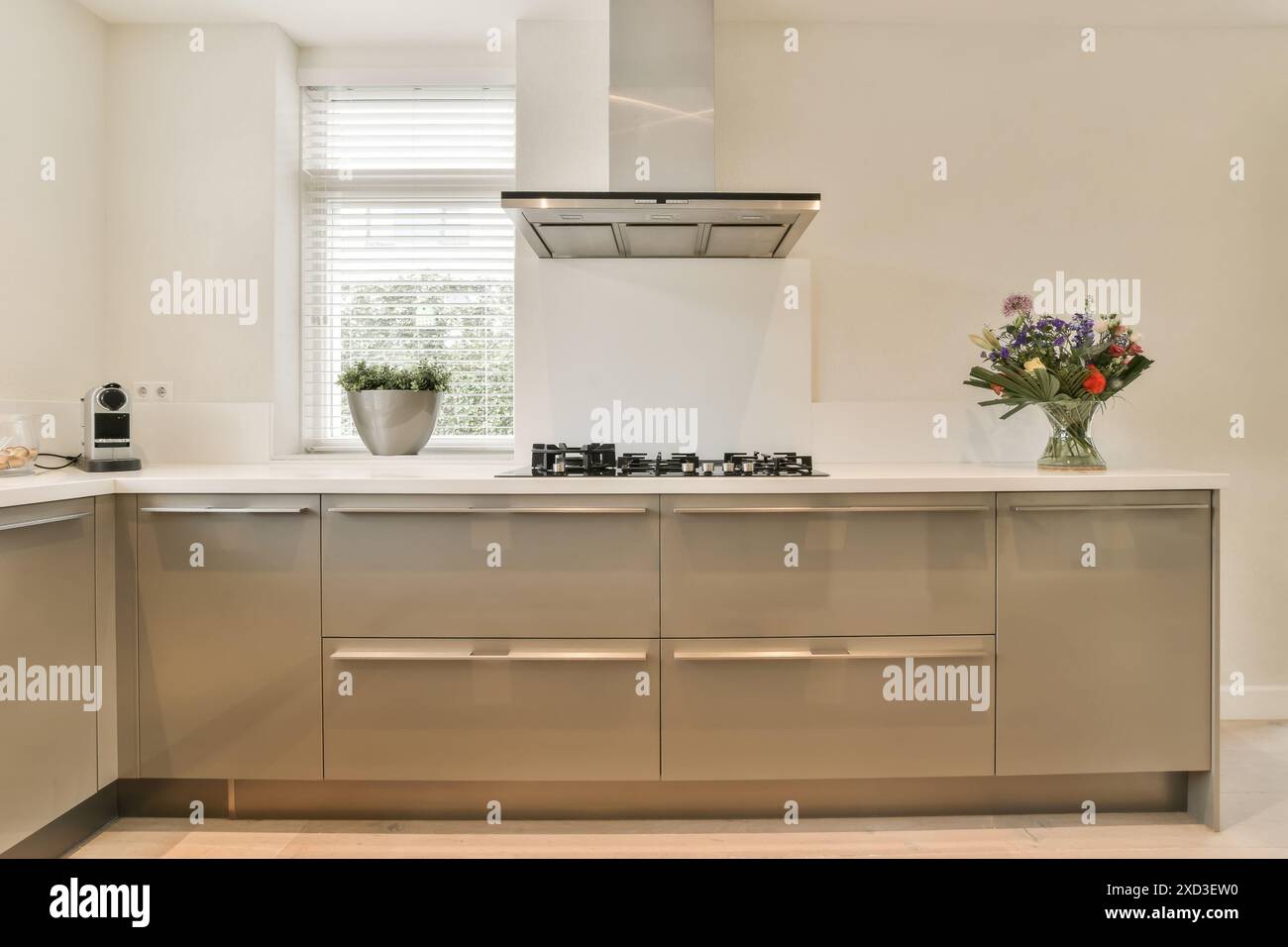 A modern kitchen with stainless steel cabinets and white countertops on ...