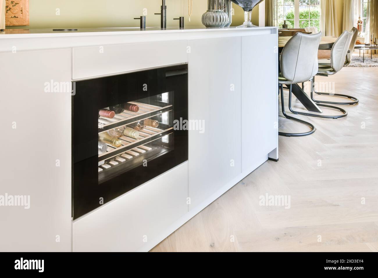 Sleek modern kitchen featuring a white island with built-in wine cooler ...