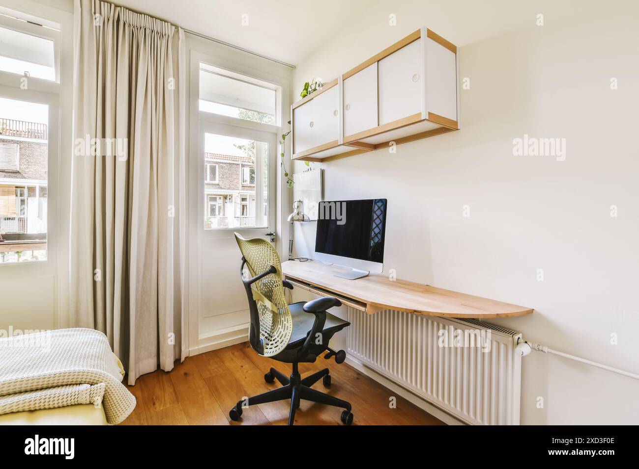 A modern home office setup featuring a sleek wooden desk, an ergonomic chair, a large computer ...