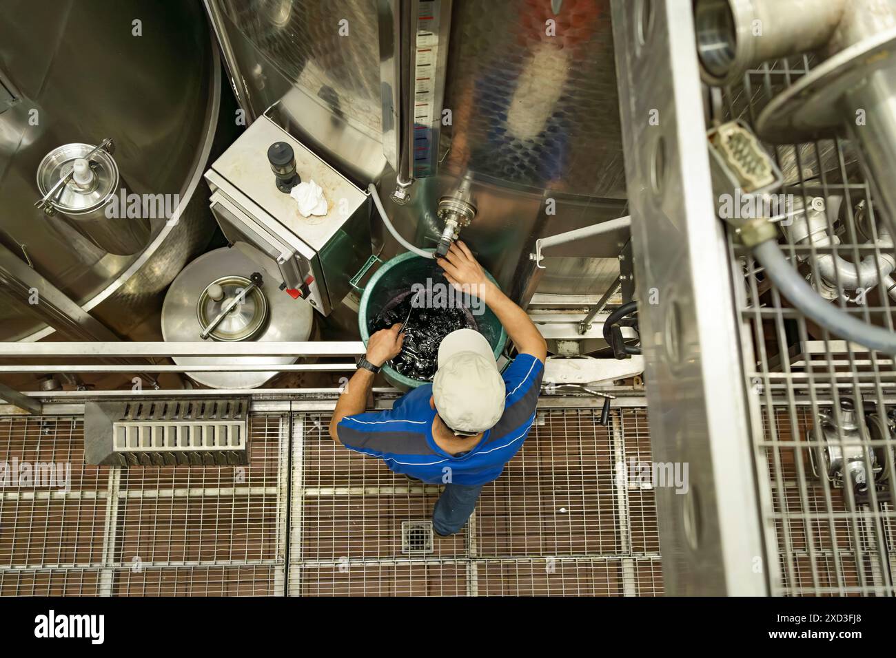 A top view of anonymous winery worker carefully supervising ...