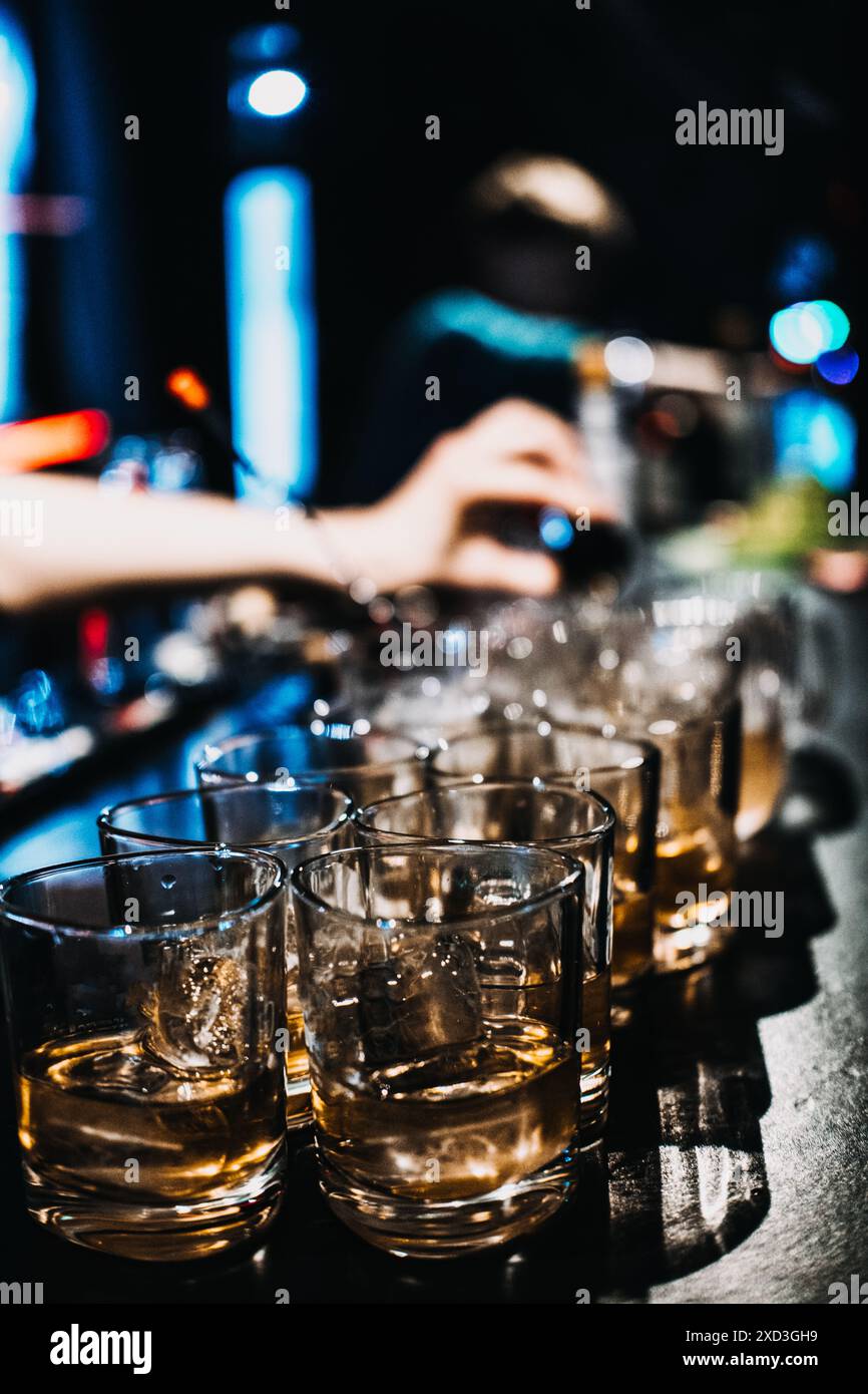 Bartender Preparing Multiple Whiskey Cocktails at a Busy Bar Stock ...