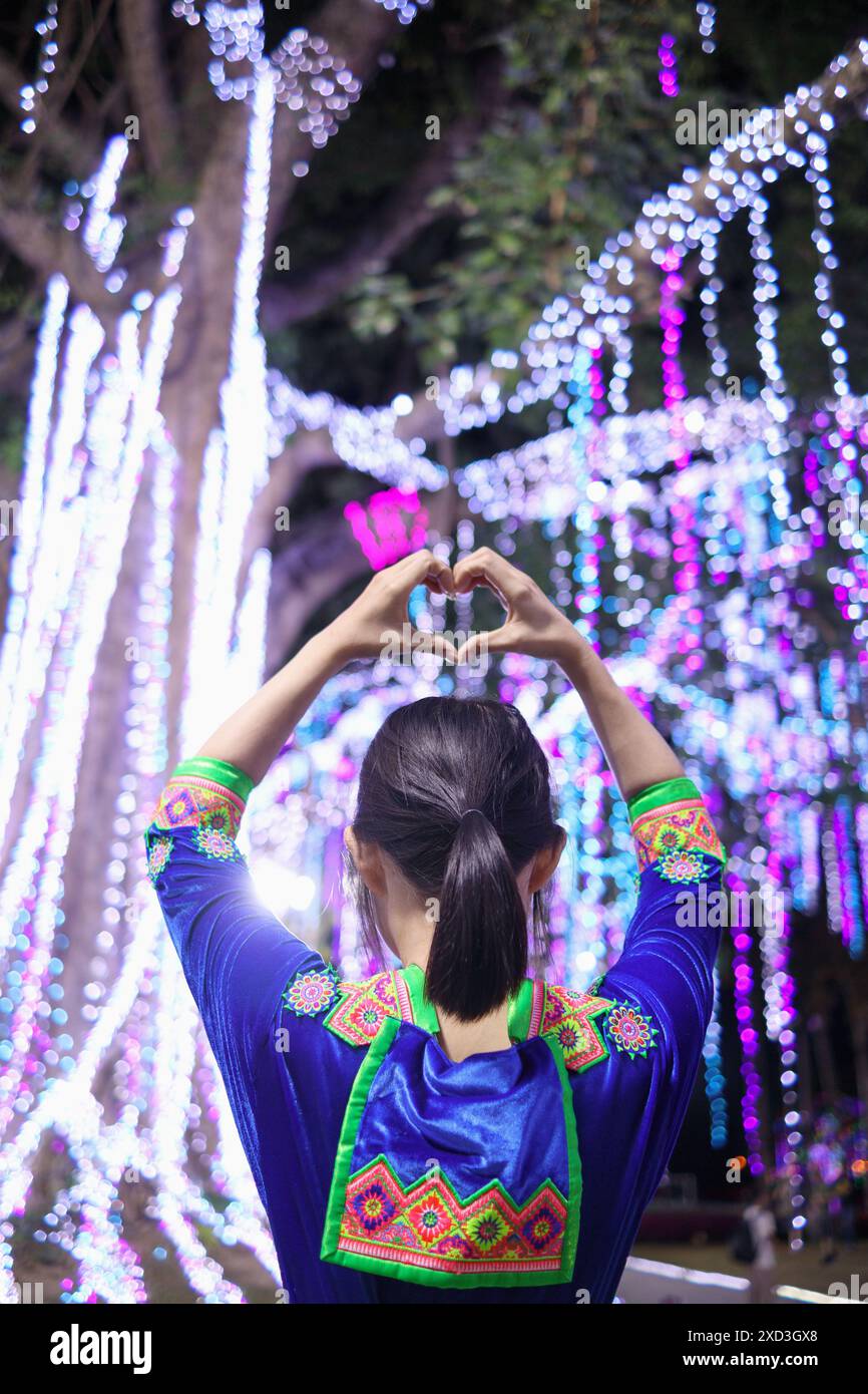 woman raises her hands to make heart symbol that represents love and ...