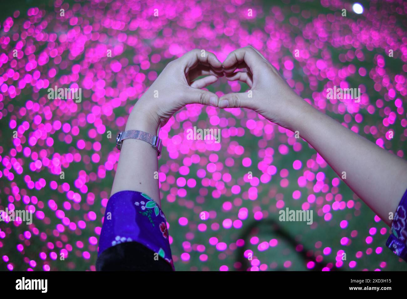 woman raises her hands to make heart symbol that represents love and ...