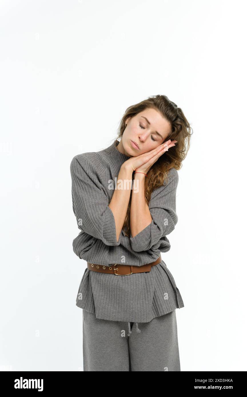 Beautiful woman pretending to sleep resting her head on her hands with ...